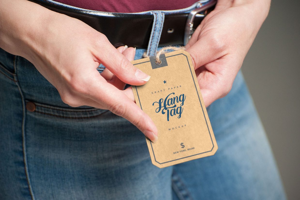 Free Hand Holding Kraft Paper Hang Tag Mockup PSD - Designbolts