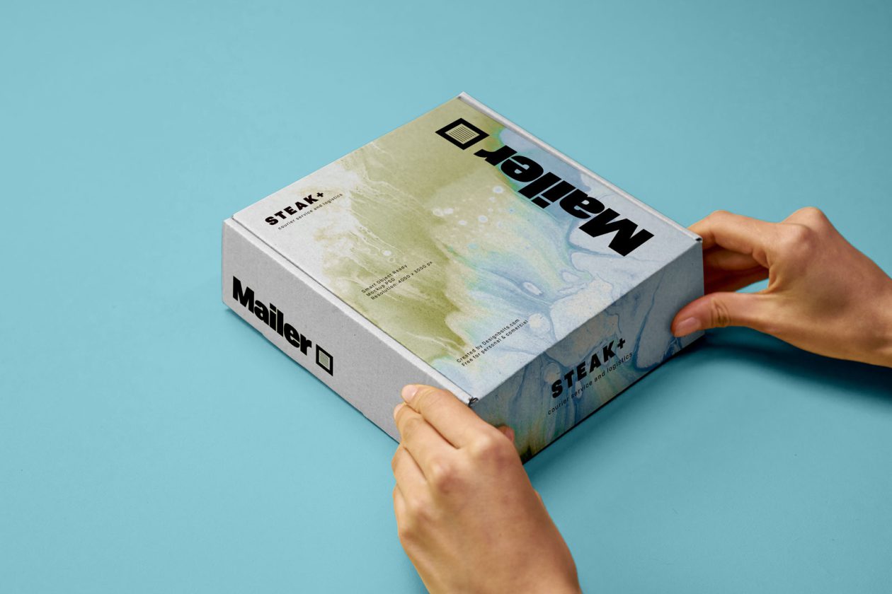 Free Hand Holding Shipping Mailer Box Mockup PSD - Designbolts